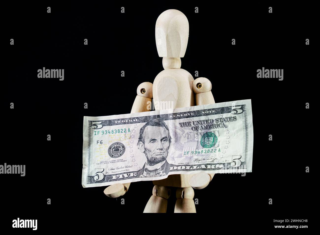Wooden dummy and five dollars banknote, business concept, puppet made ...