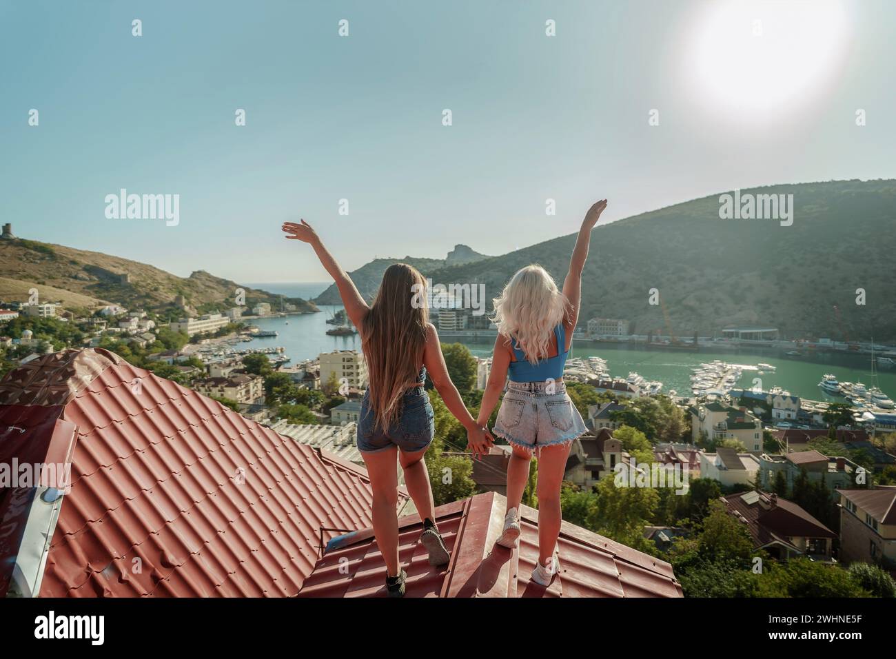 women standing on rooftop, enjoys town view and sea mountains. Peaceful ...