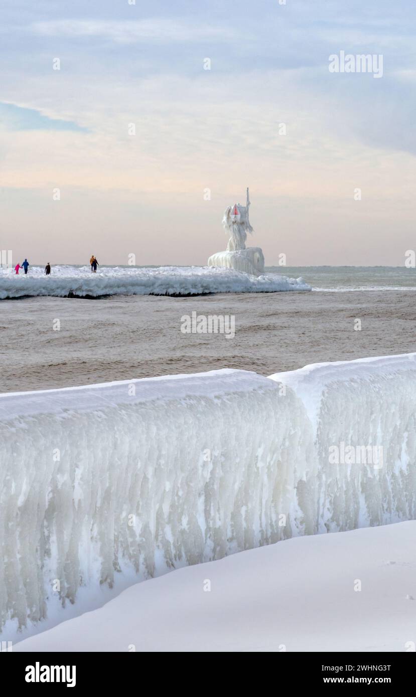 Tourists hike out carefully over a frozen boardwalk, to see the ice ...