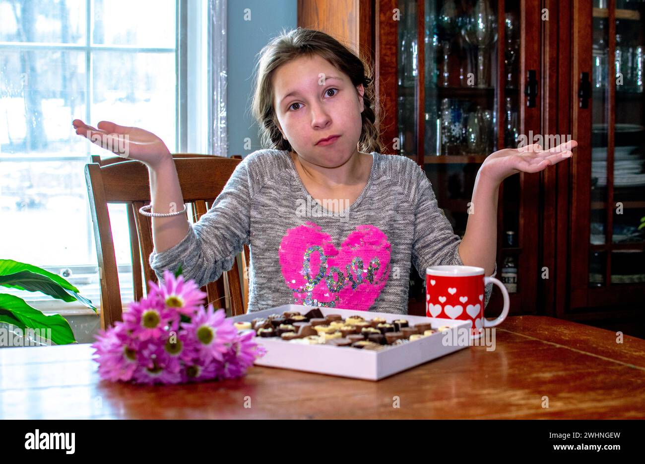 young girl docent know what chocolate to choose, from this fancy box of ...