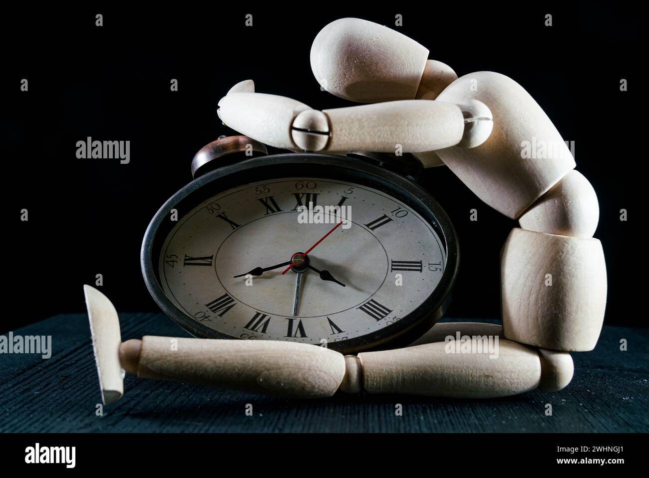 Wooden dummy and analogic clock, time concept, puppet made of wood, art ...