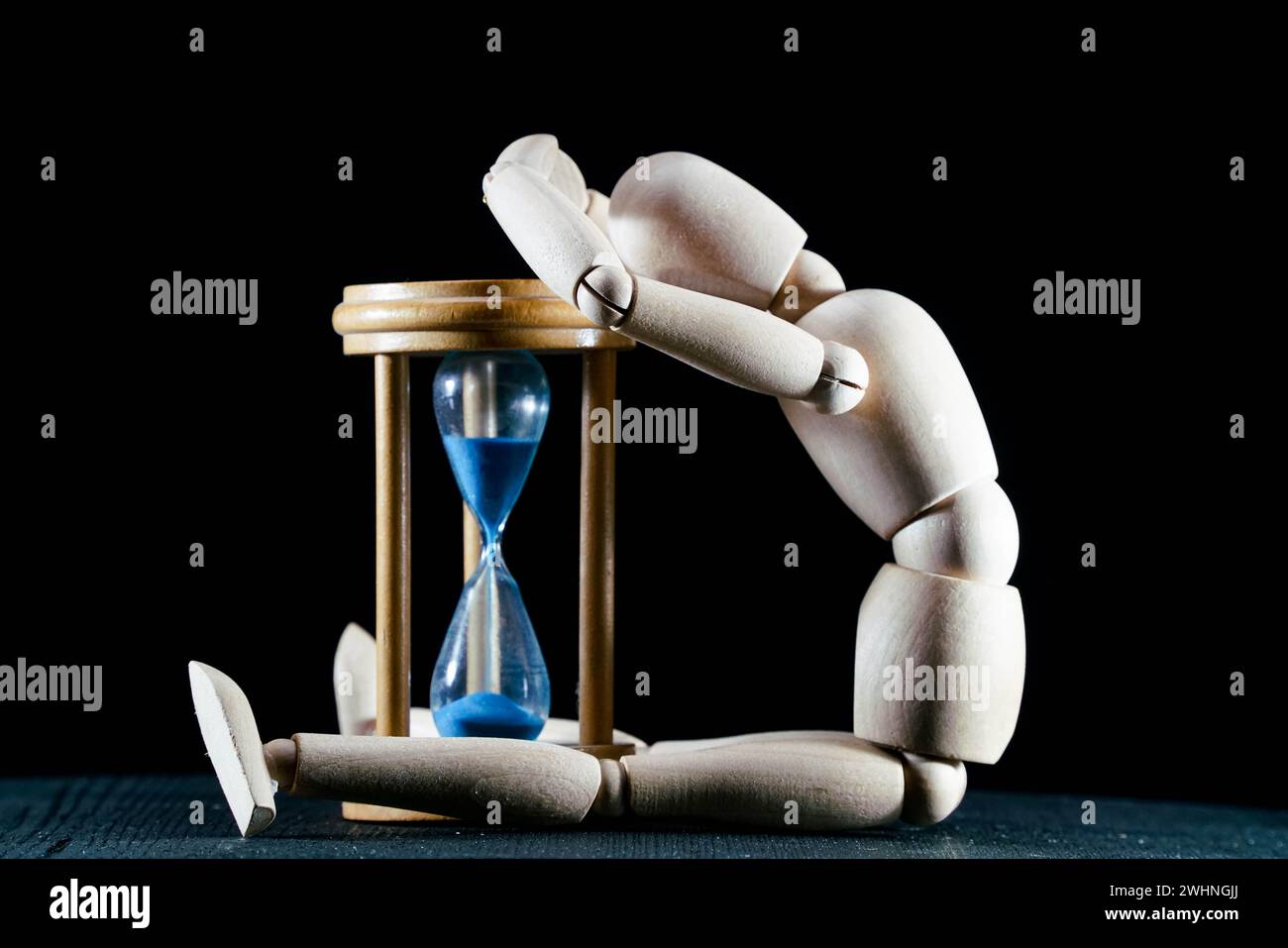 Wooden dummy and hourglass sandglass vintage clock, time concept ...