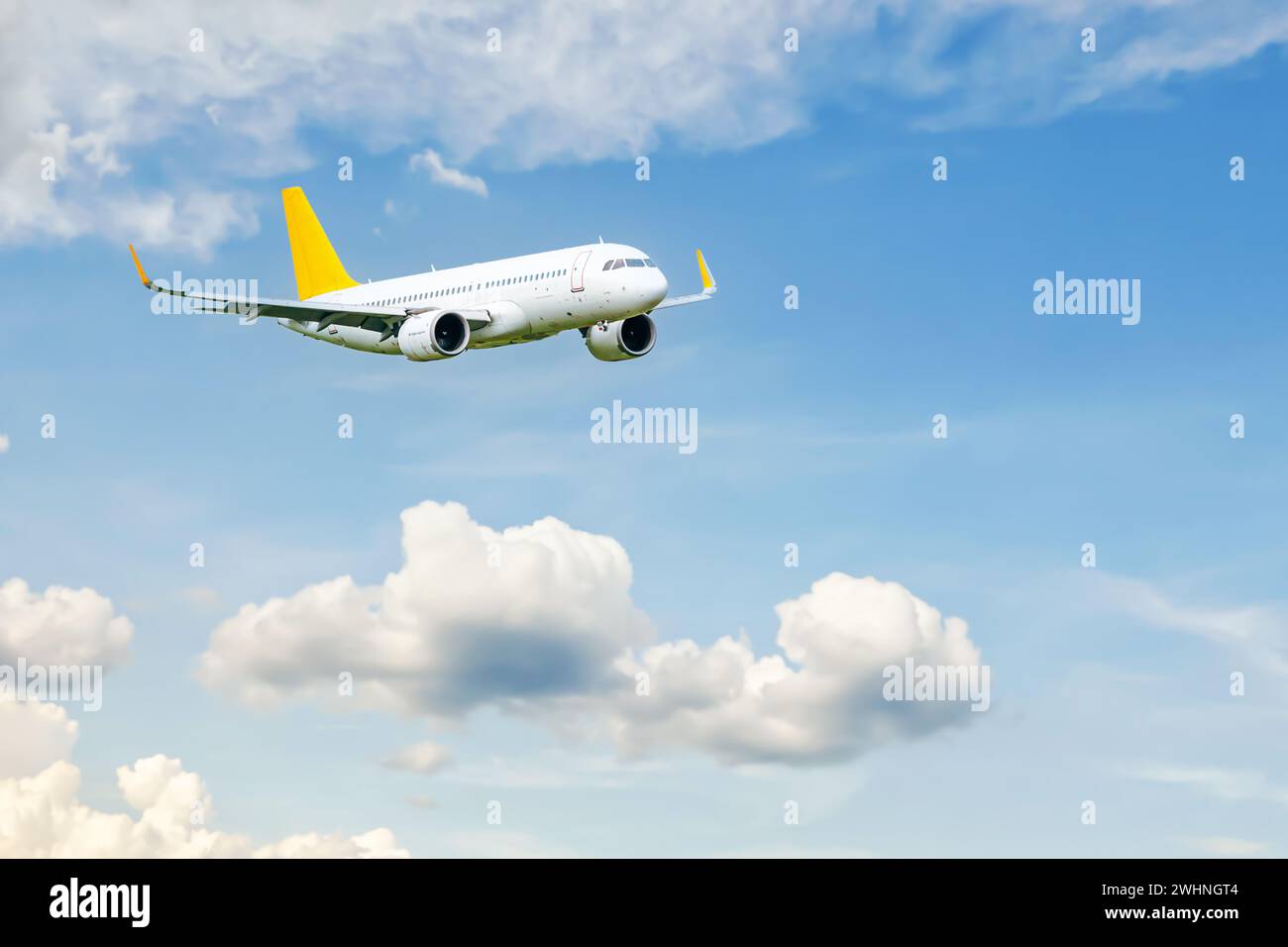Airplane in the blue sky with clouds from below, close up. high flying ...