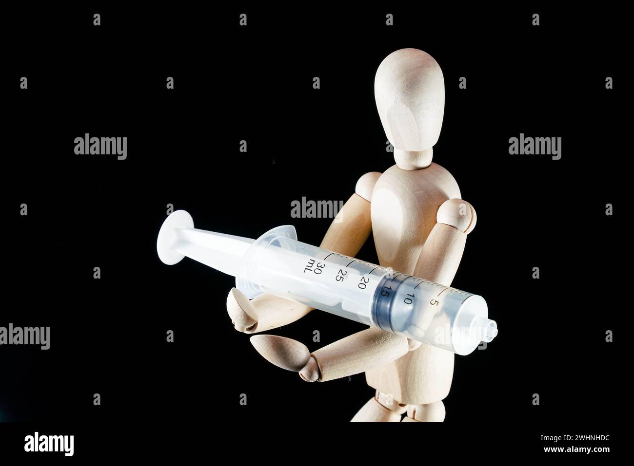 Wooden dummy figurine and syringe, medical concept, vaccine concept ...