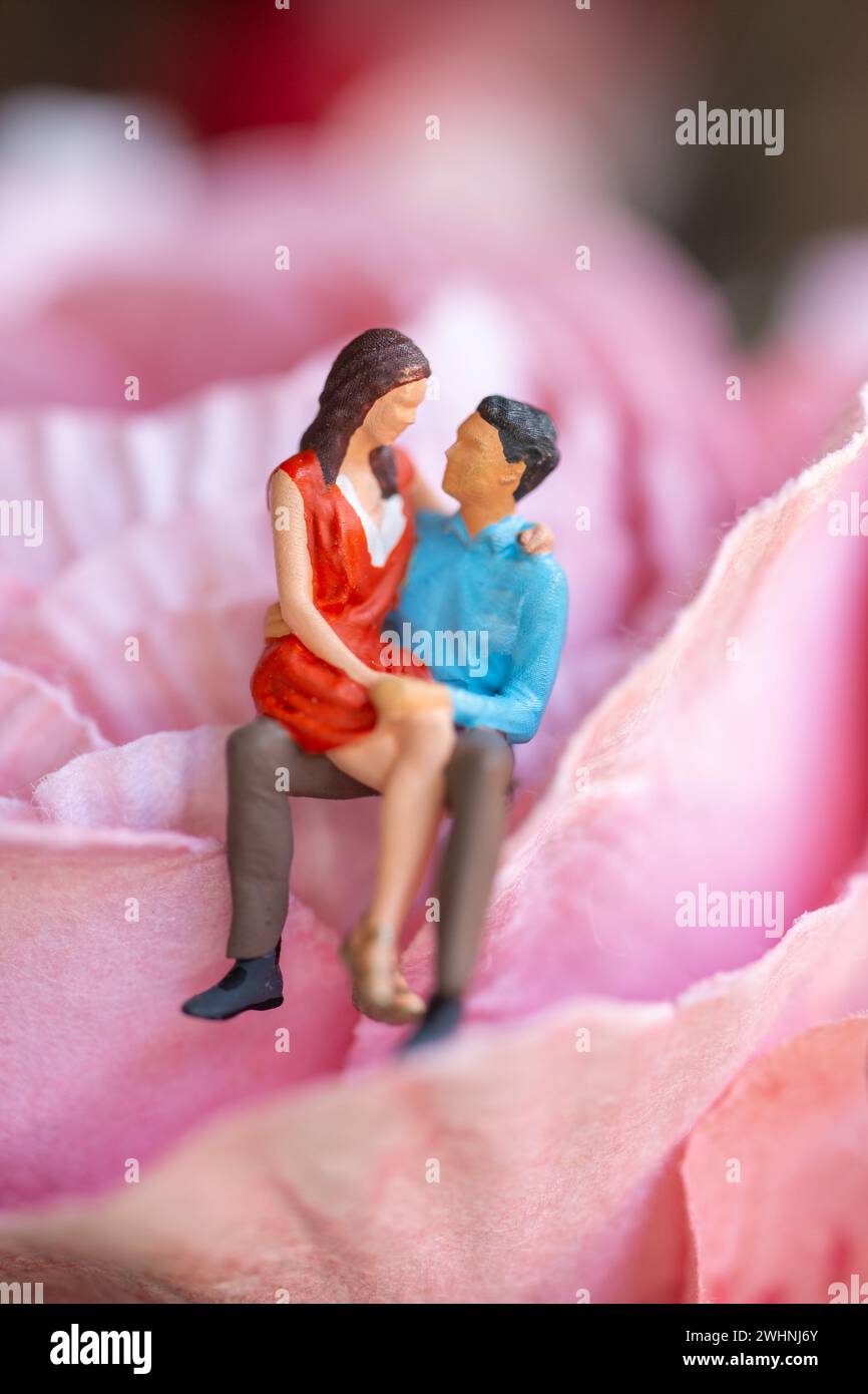 Miniature people Young girl sitting on her boy lap Stock Photo - Alamy