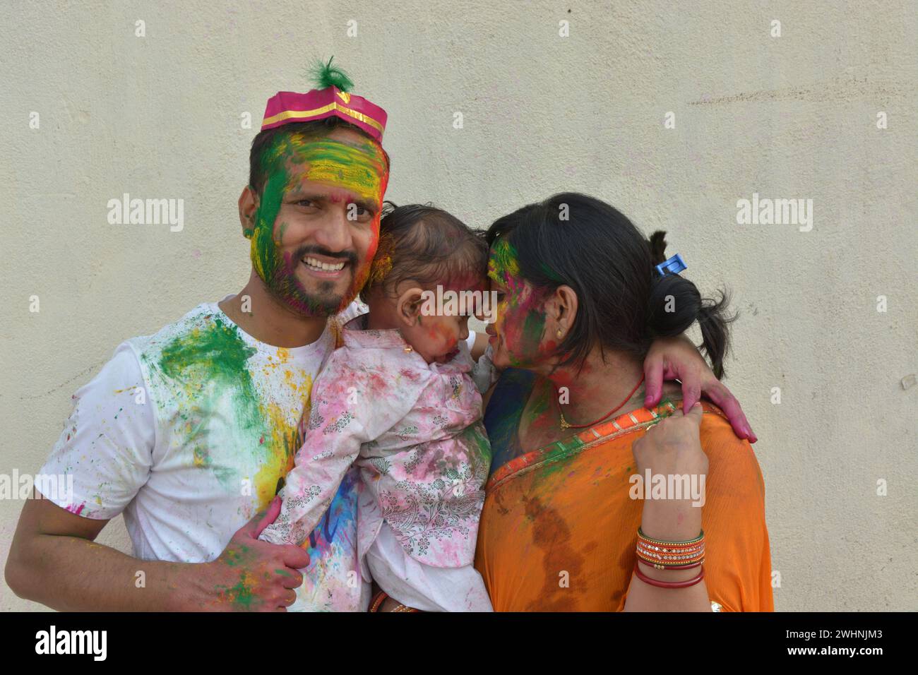 young couple playing holi with children. Happy holi. Holi India Stock ...