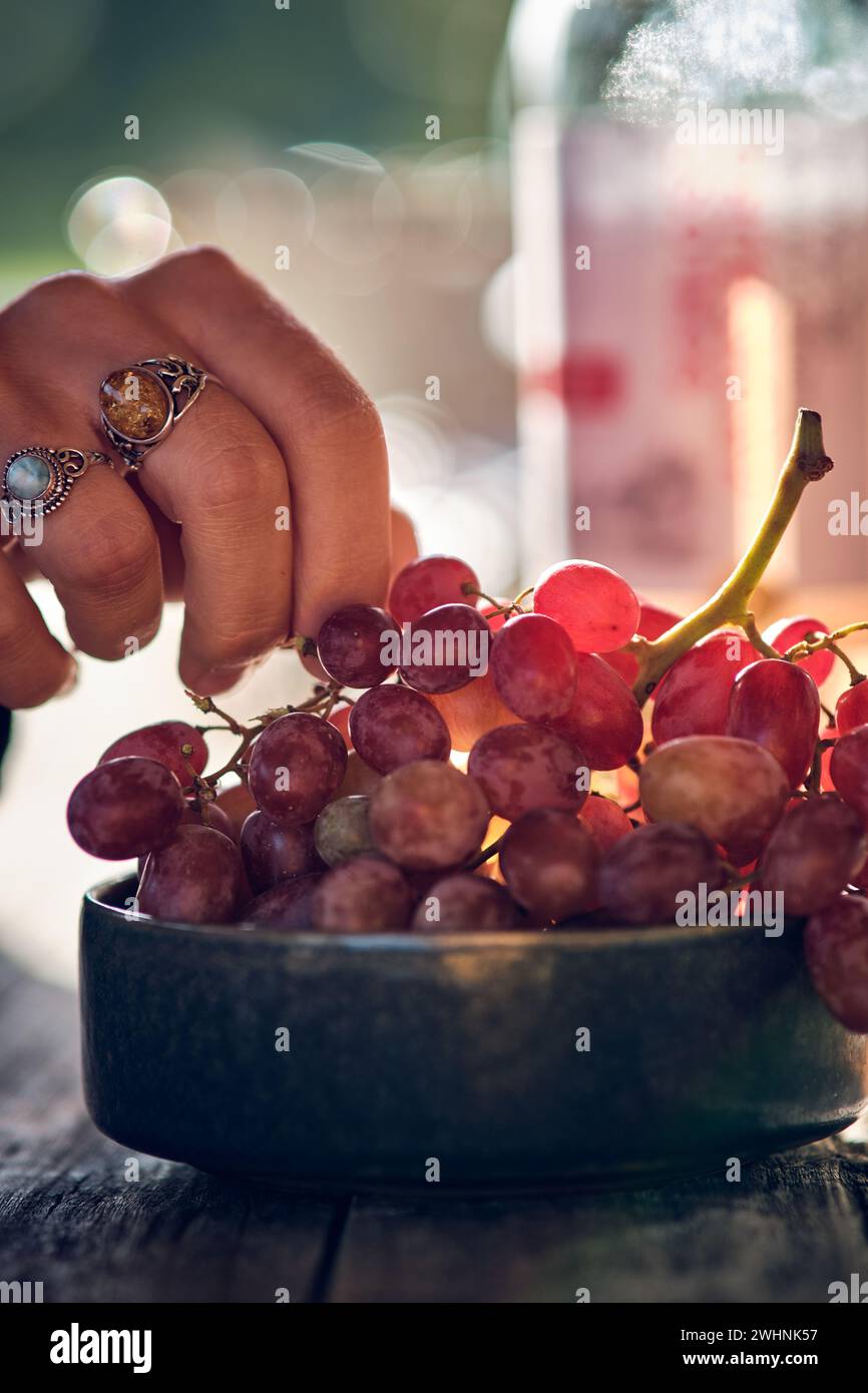 Hand carefully picking some red grapes Stock Photo - Alamy