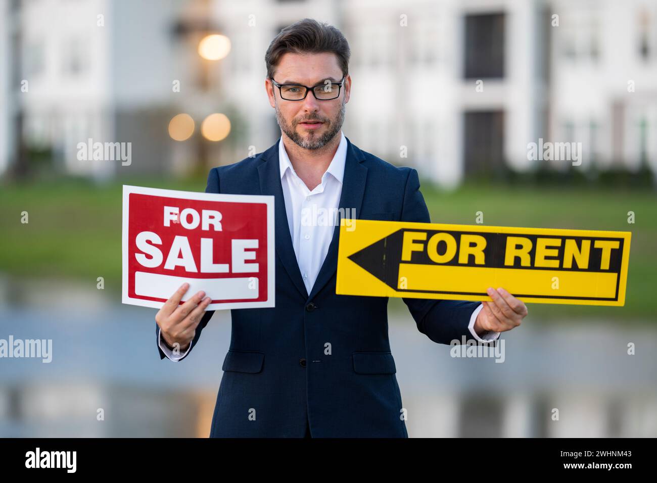 Handsome real estate agent holding banner house for sale. House with ...