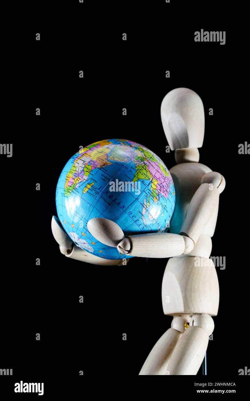 Wooden dummy and earth globe, ecology concept, puppet made of wood, art ...