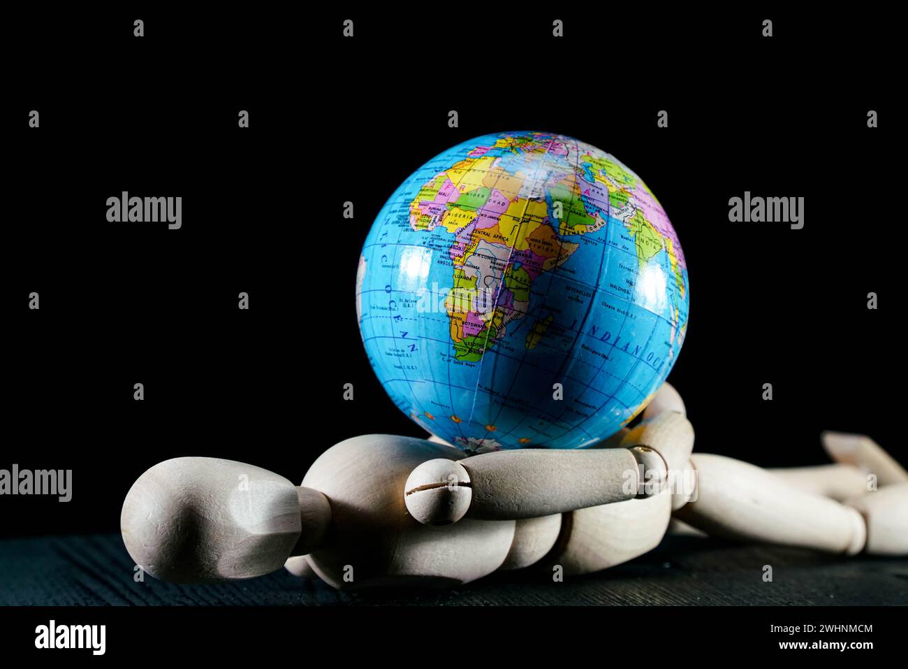 Wooden dummy and earth globe, ecology concept, puppet made of wood, art ...