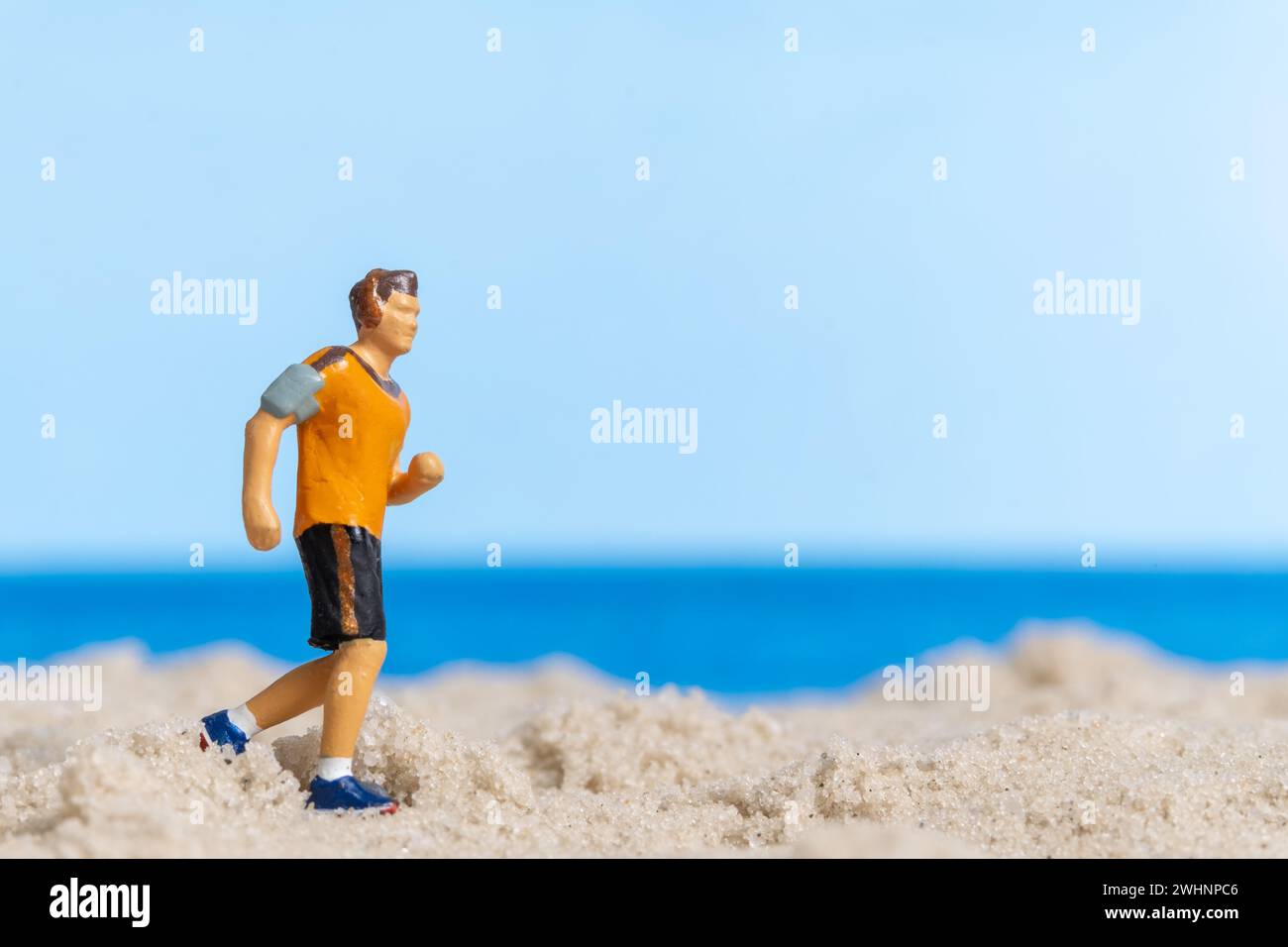 Miniature people running on The beach Stock Photo - Alamy