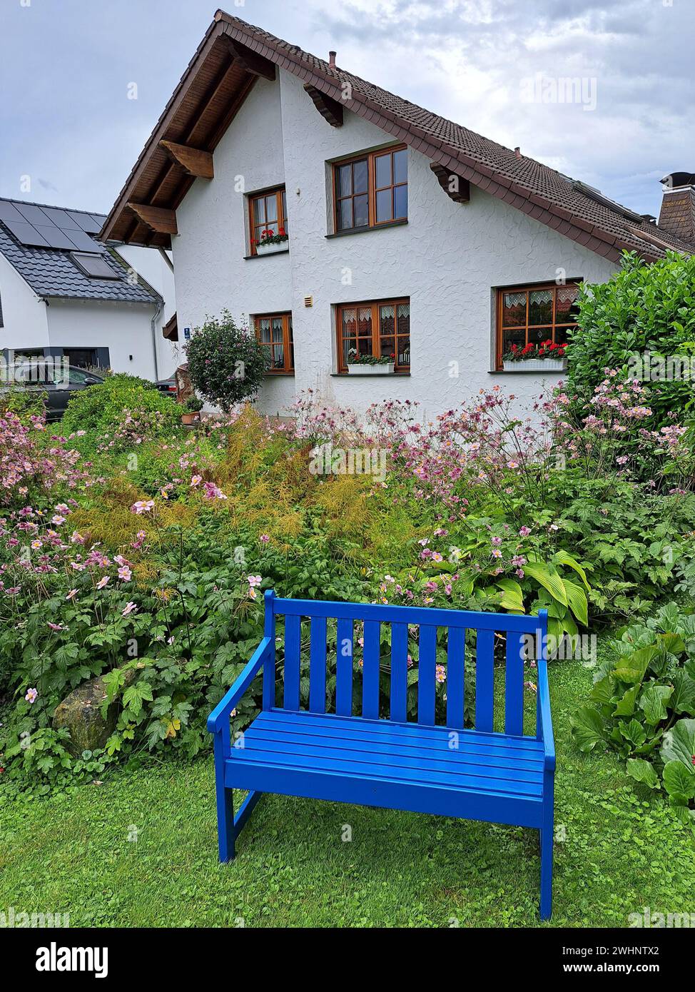 Blue bench in front of a country-style detached house Stock Photo - Alamy