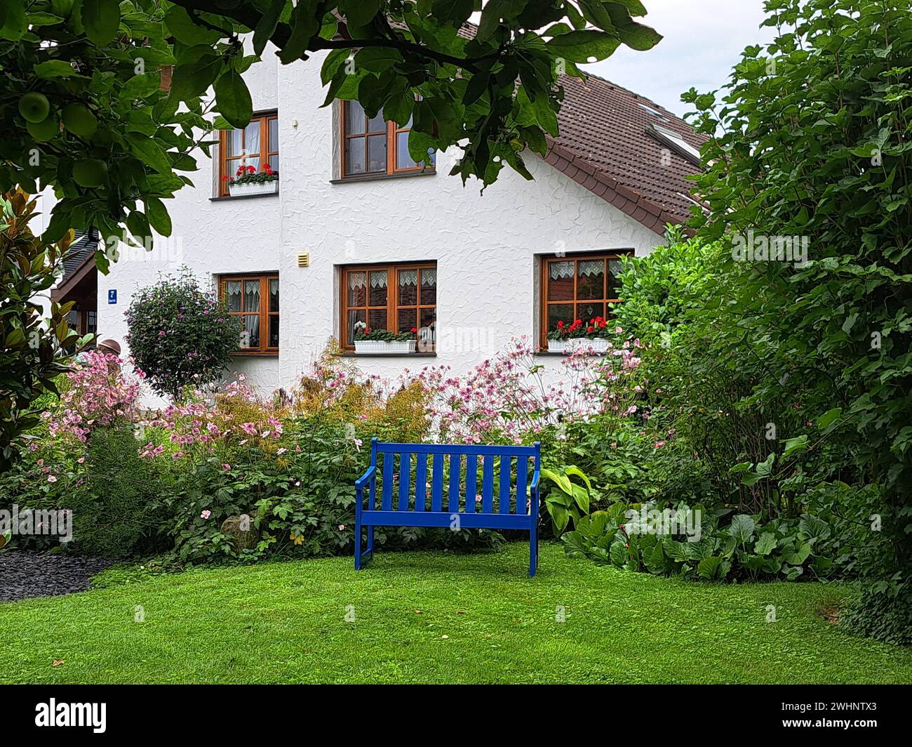 Blue bench in front of a country-style detached house Stock Photo - Alamy