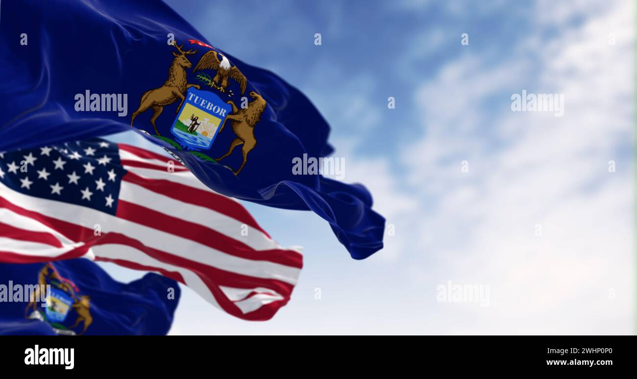 Flags of Michigan and the United States waving in the wind on a clear ...