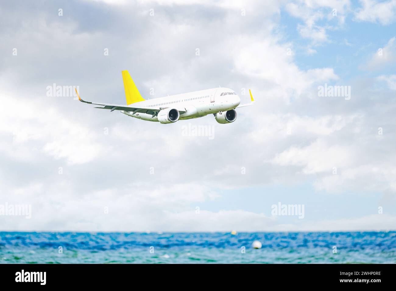 Airplane in the blue sky with clouds flying over the Ocean. close up ...