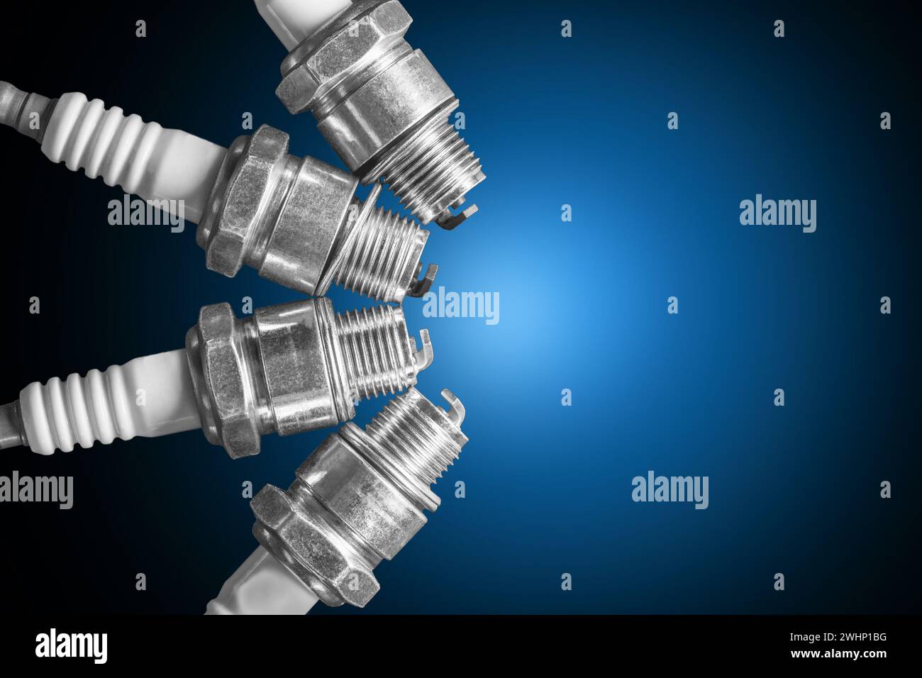 Four spark plugs for a two-stroke engine on a blue gradient background ...