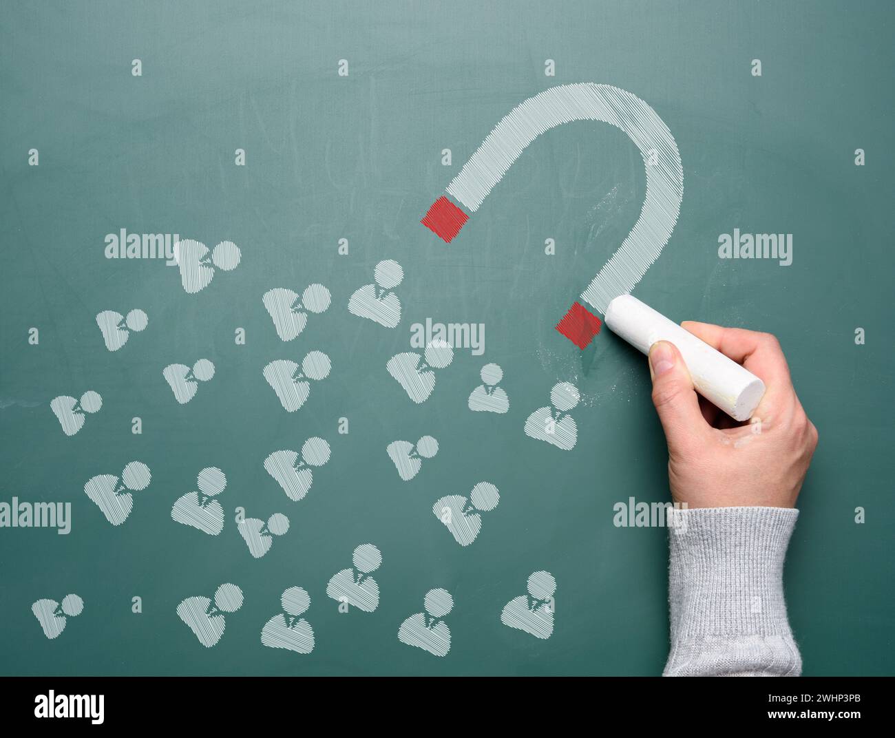 Magnet and icons drawn with white chalk. The concept of attracting new ...
