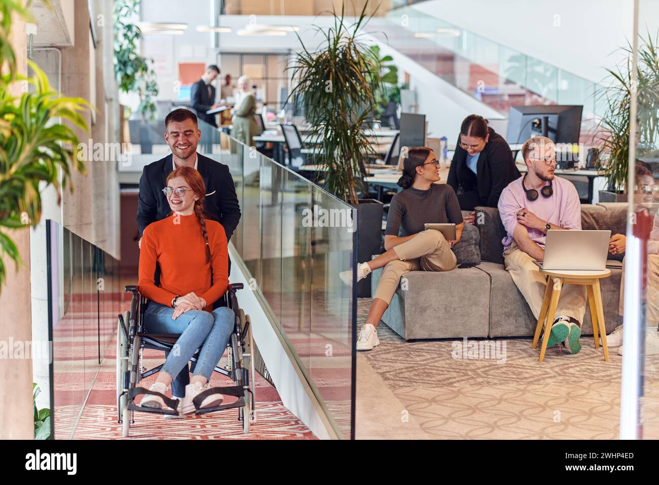 A company director assists his business colleague in a wheelchair ...