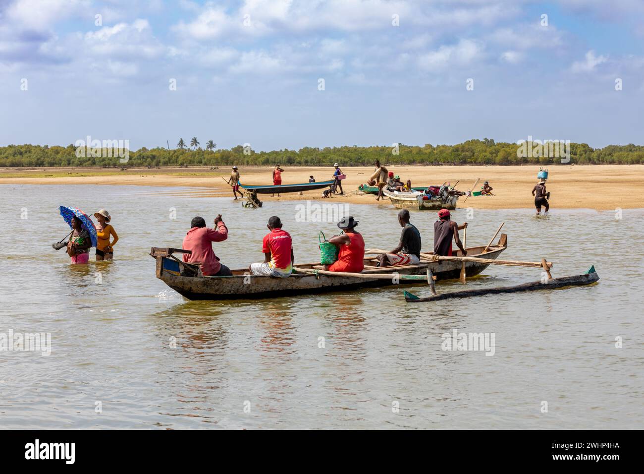 Malagasy family in traditional wooden boat crossing River in Morondava, Madagascar Stock Photo ...