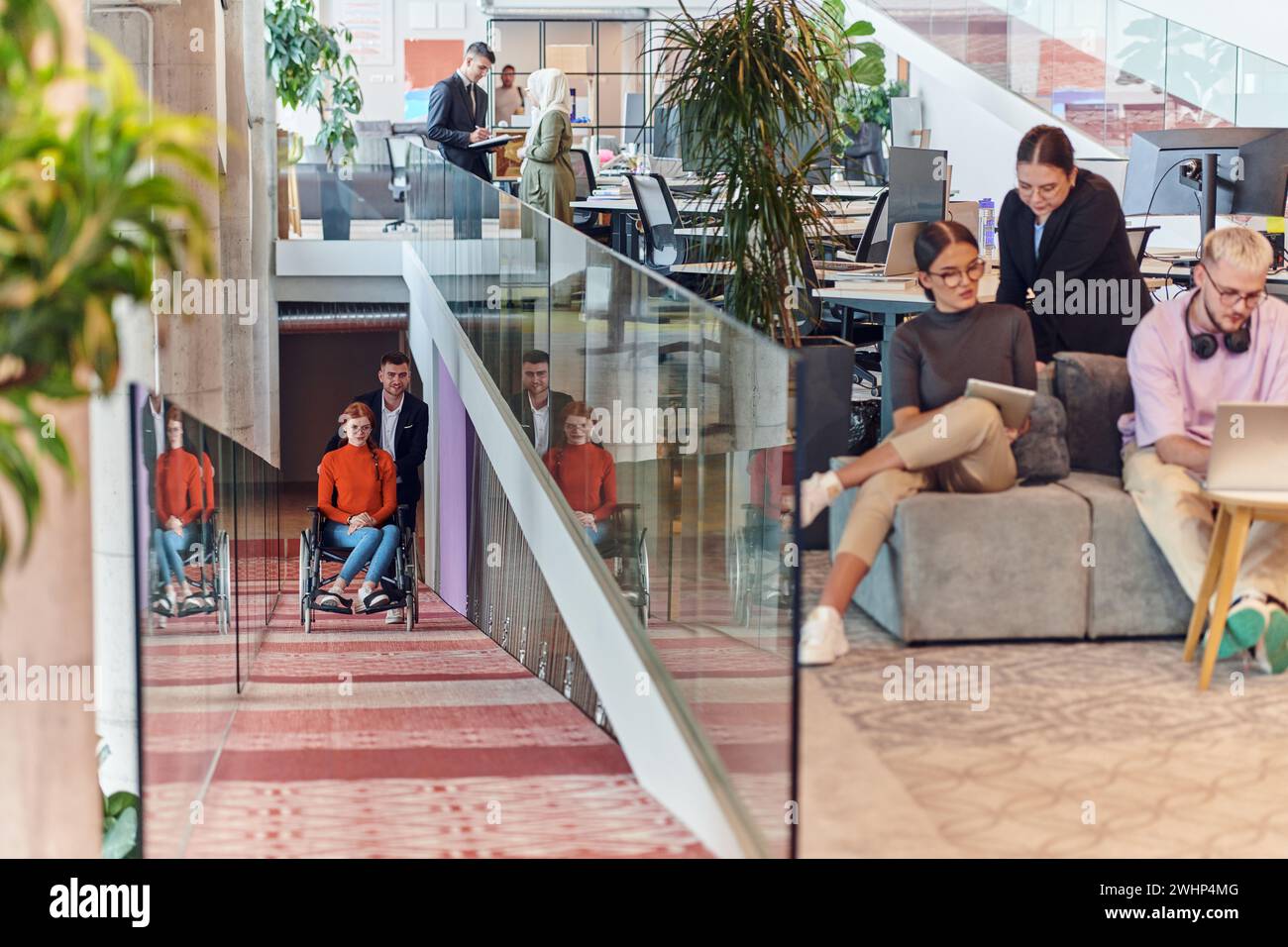A company director assists his business colleague in a wheelchair ...