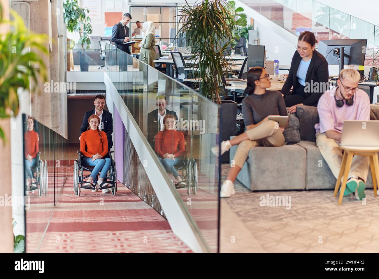 A company director assists his business colleague in a wheelchair ...