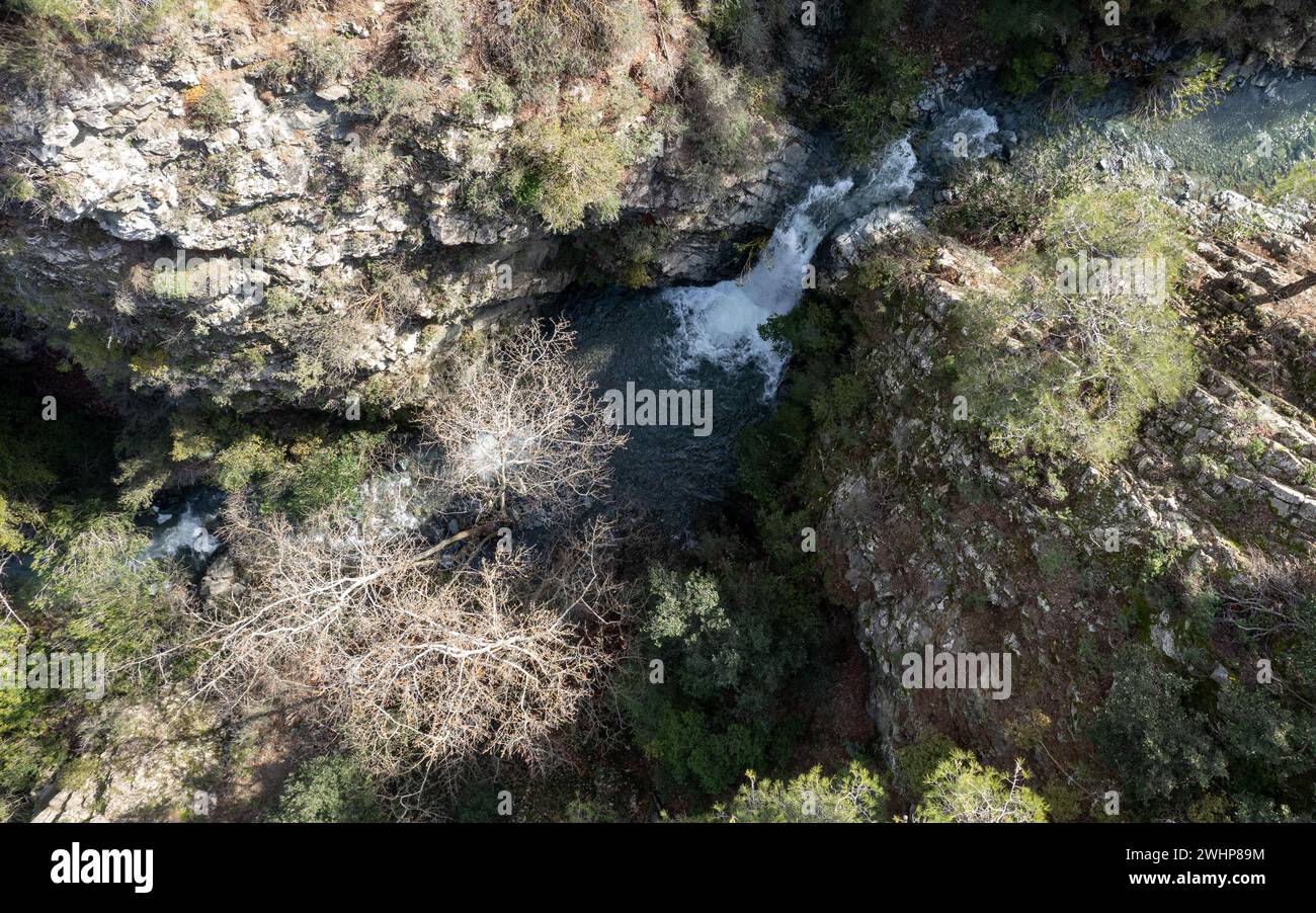 Drone aerial of waterfall flowing from a rocky cliff in the gorge ...