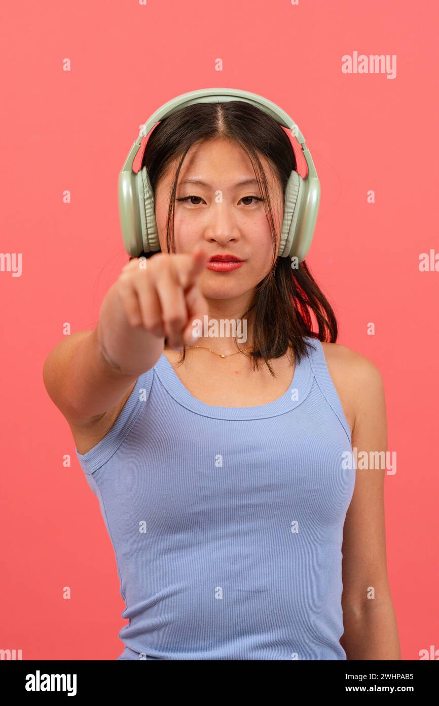 Vertical portrait Young Serious Chinese Woman Pointing Finger On Pink ...