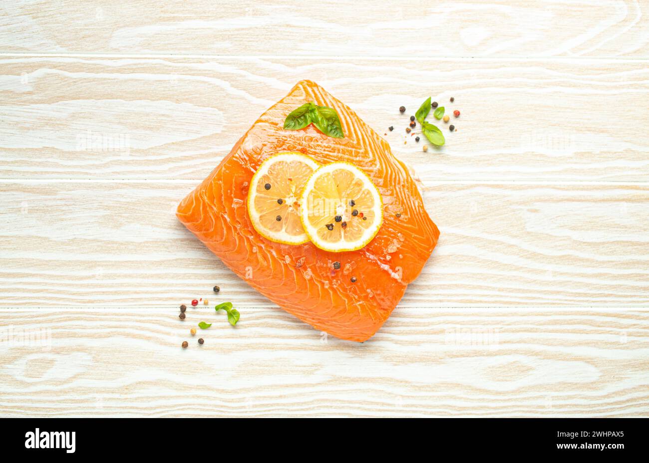 Fresh raw salmon marbled fillet on white rustic wooden table background ...