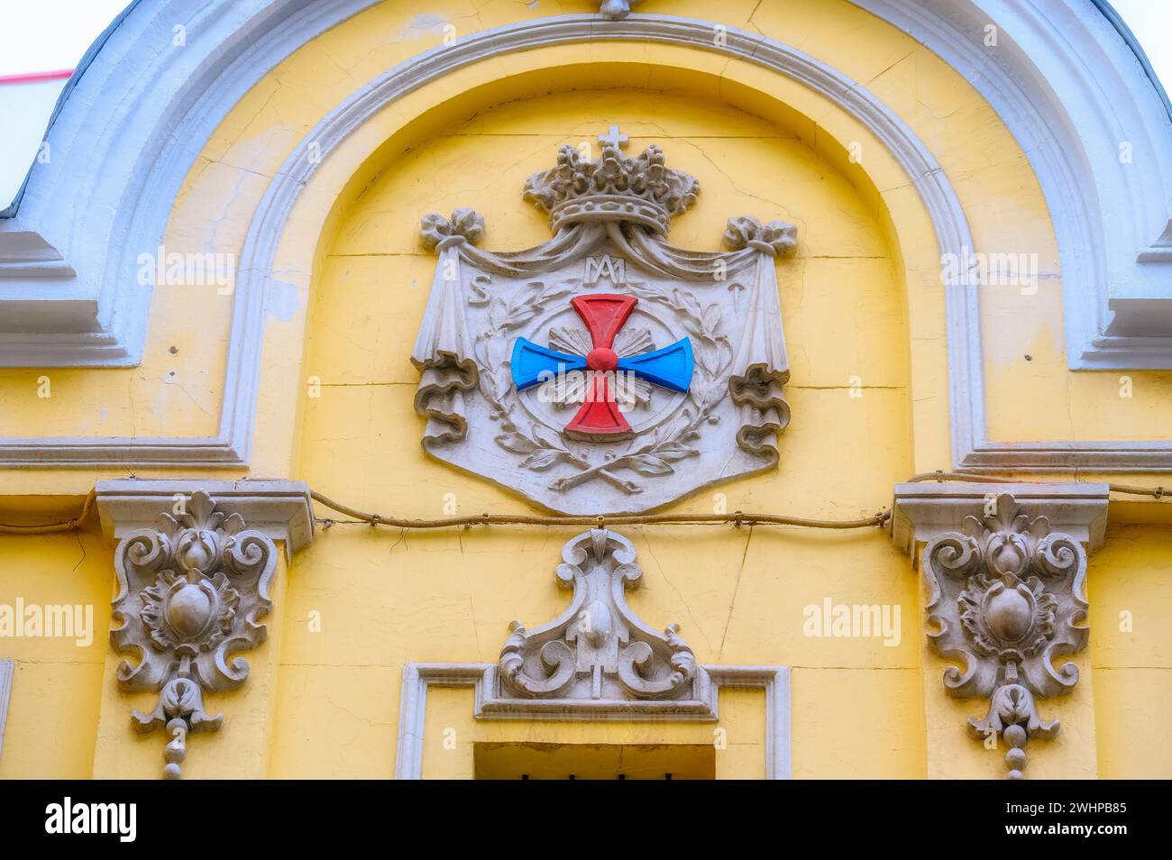 Coat of arms with a cross and a royal crown below an arch. Architecture ...