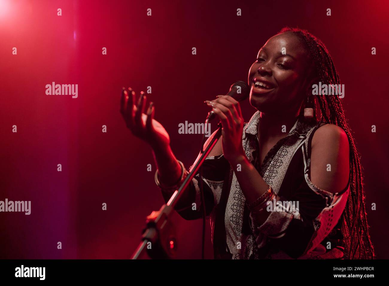 Waist up portrait of talented Black woman singing into microphone ...