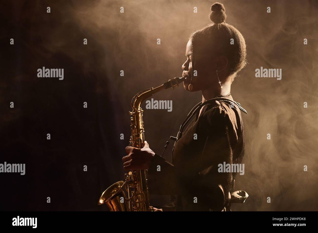 Ambient side view portrait of Black young woman performing jazz music ...