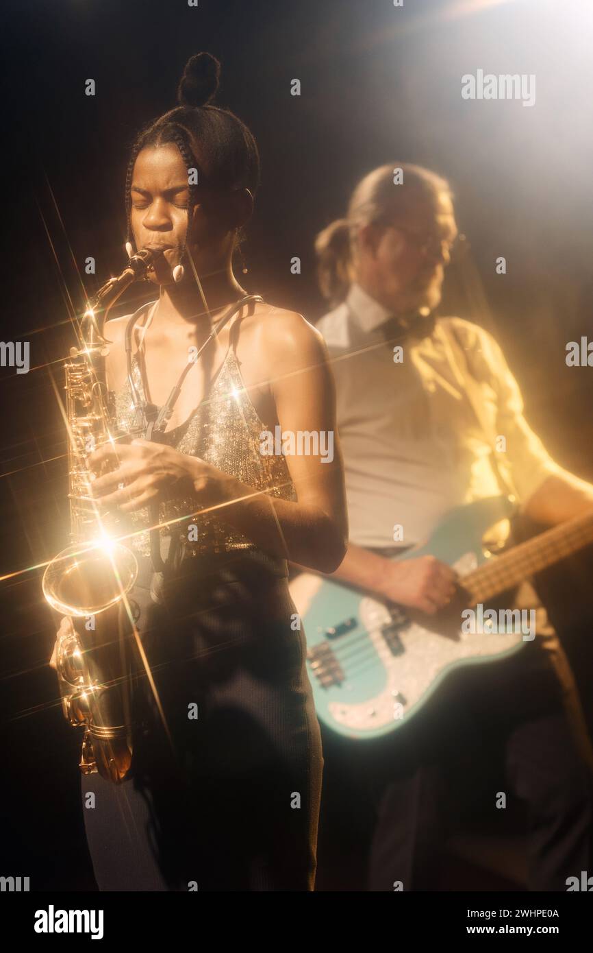 Vertical portrait of African American woman playing saxophone ...