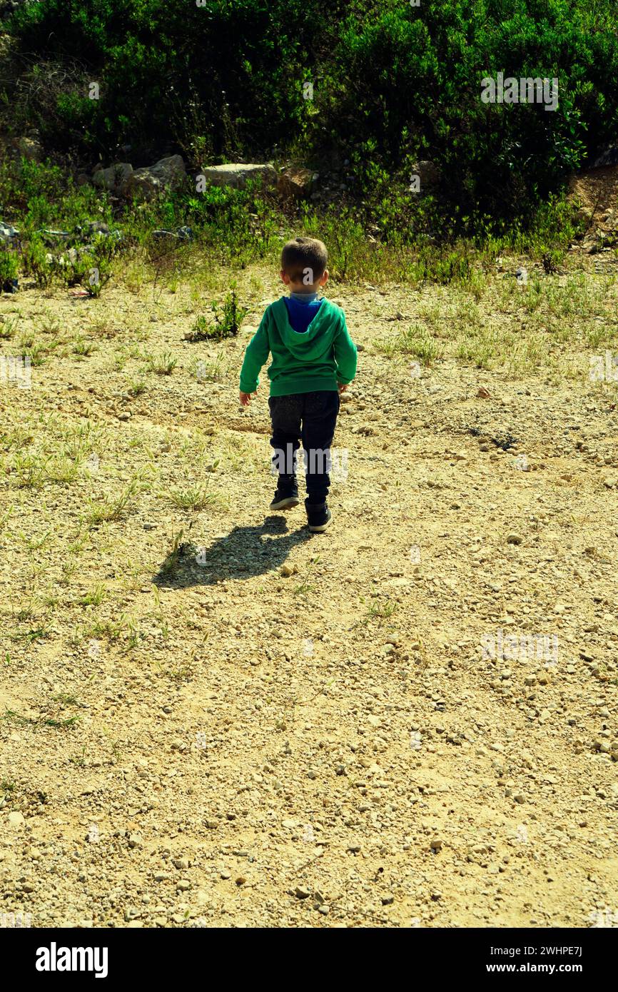 Rear view of little boy walking away outdoors Stock Photo - Alamy