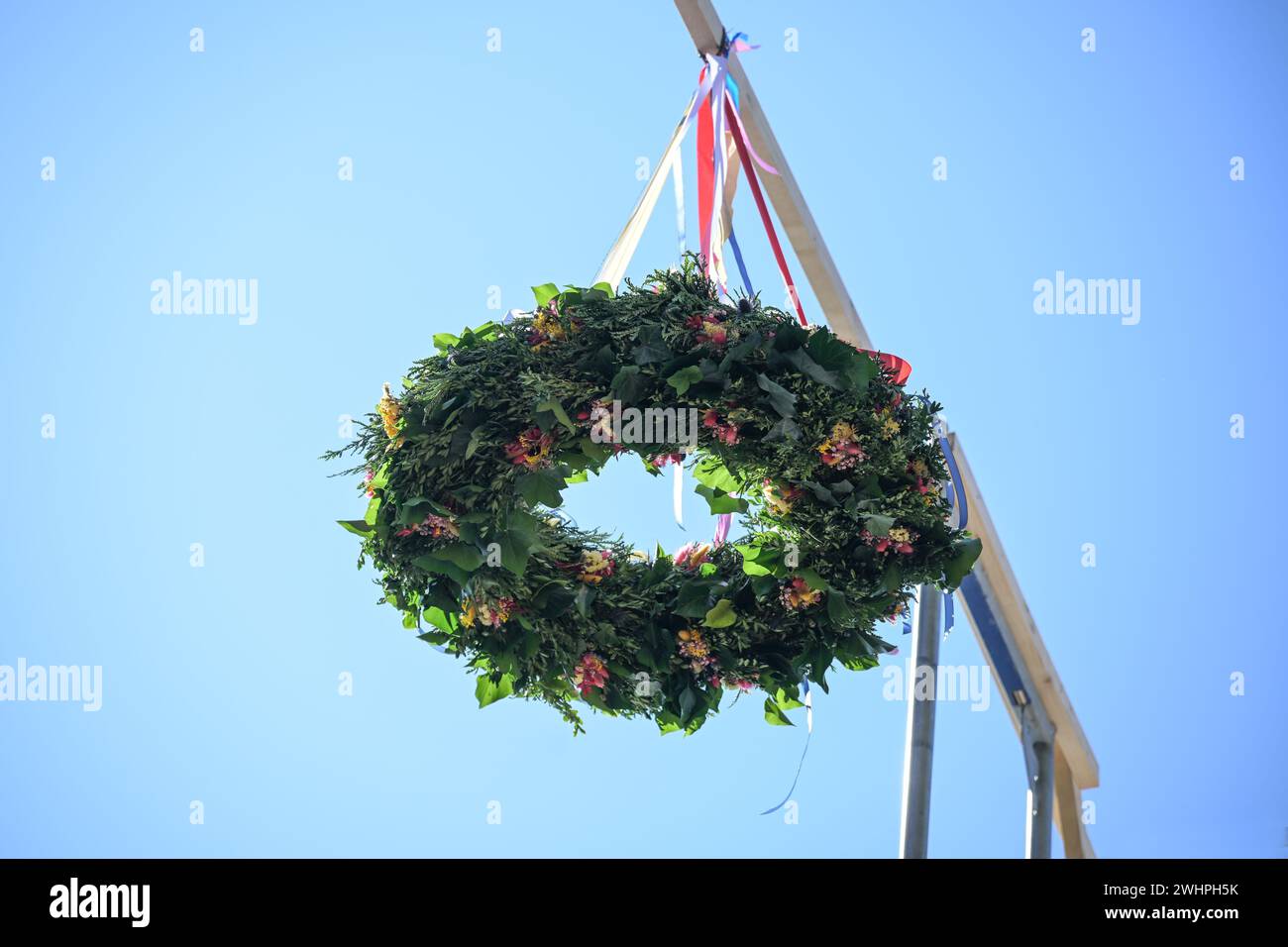 Topping out wreath tied from evergreen branches and flowers hanging ...