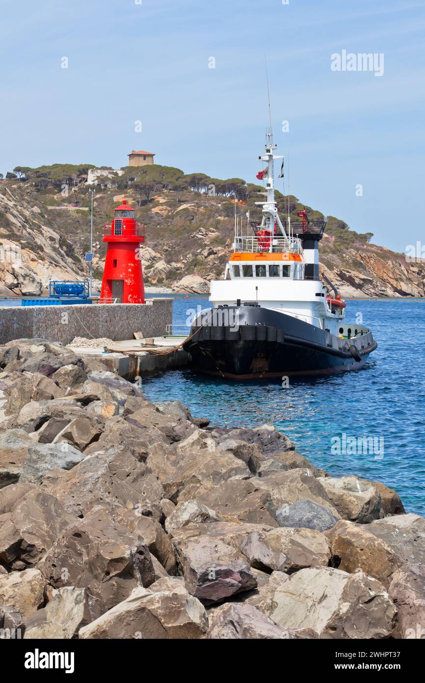 Fishing Trawler and Small Red Lighthouse Stock Photo - Alamy