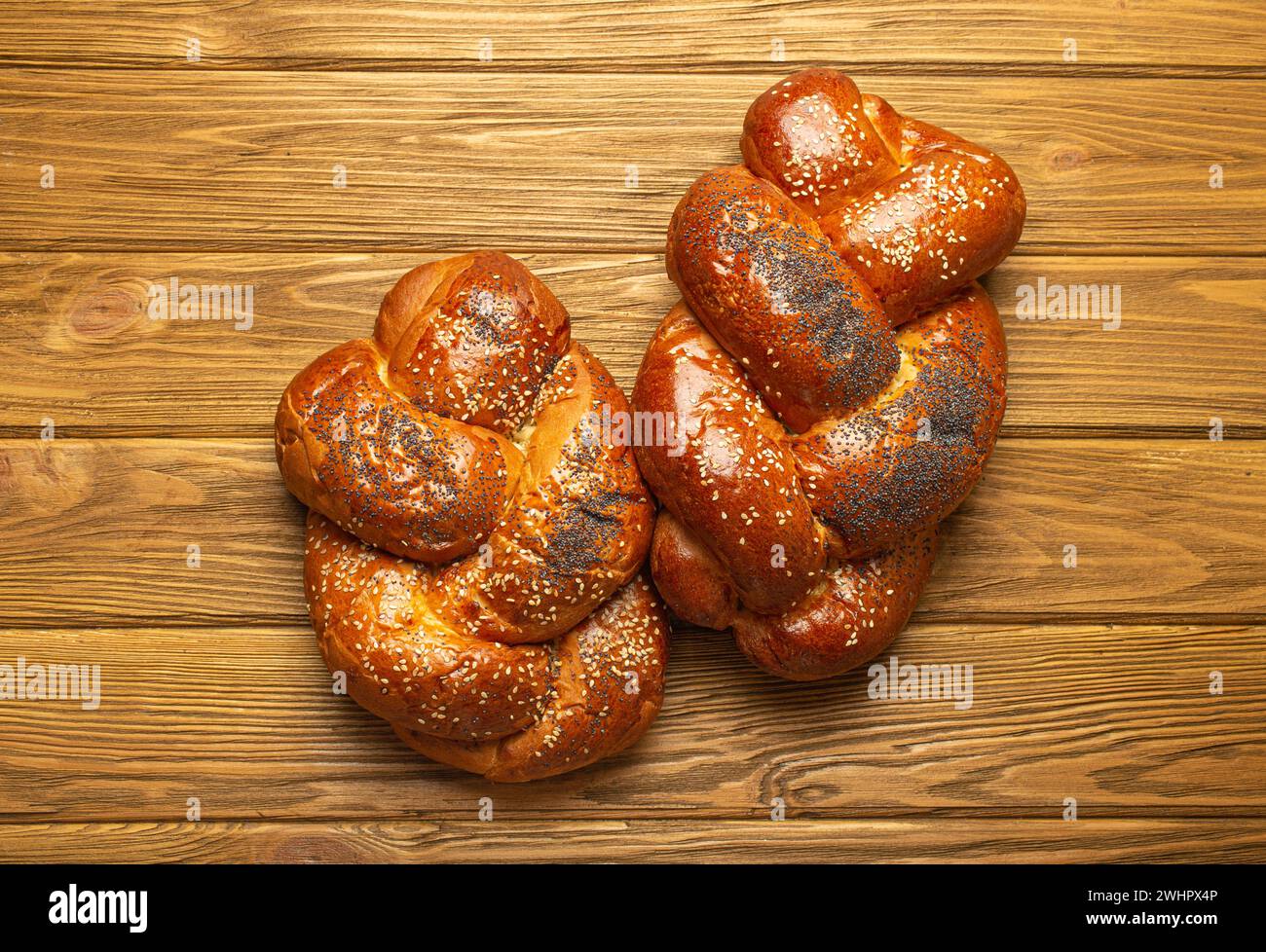 Two reshly baked Challah bread covered with poppy and sesame seeds, top ...