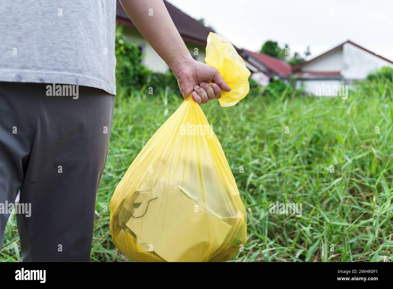 Man Volunteer charity holding garbage yellow bag and plastic bottle ...