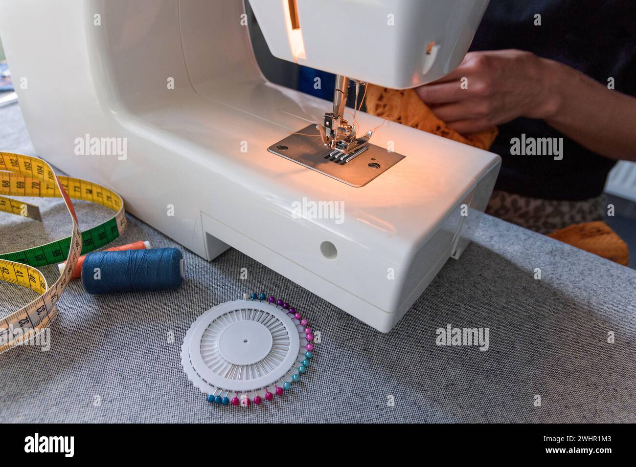 Using sewing machine with pins, reels of colour threads and other ...