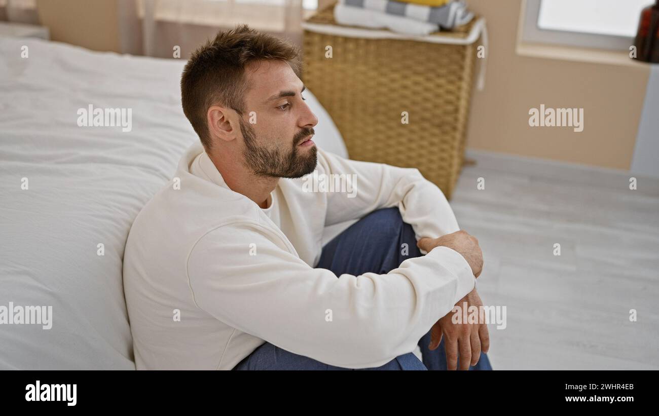 Stressed young hispanic man, awfully awake, sitting alone in a homey ...