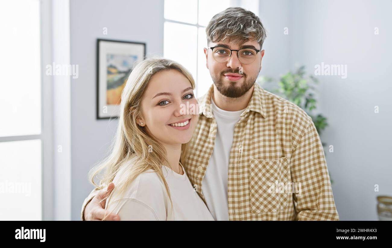 A loving couple embraces in a bright modern living room, exuding ...