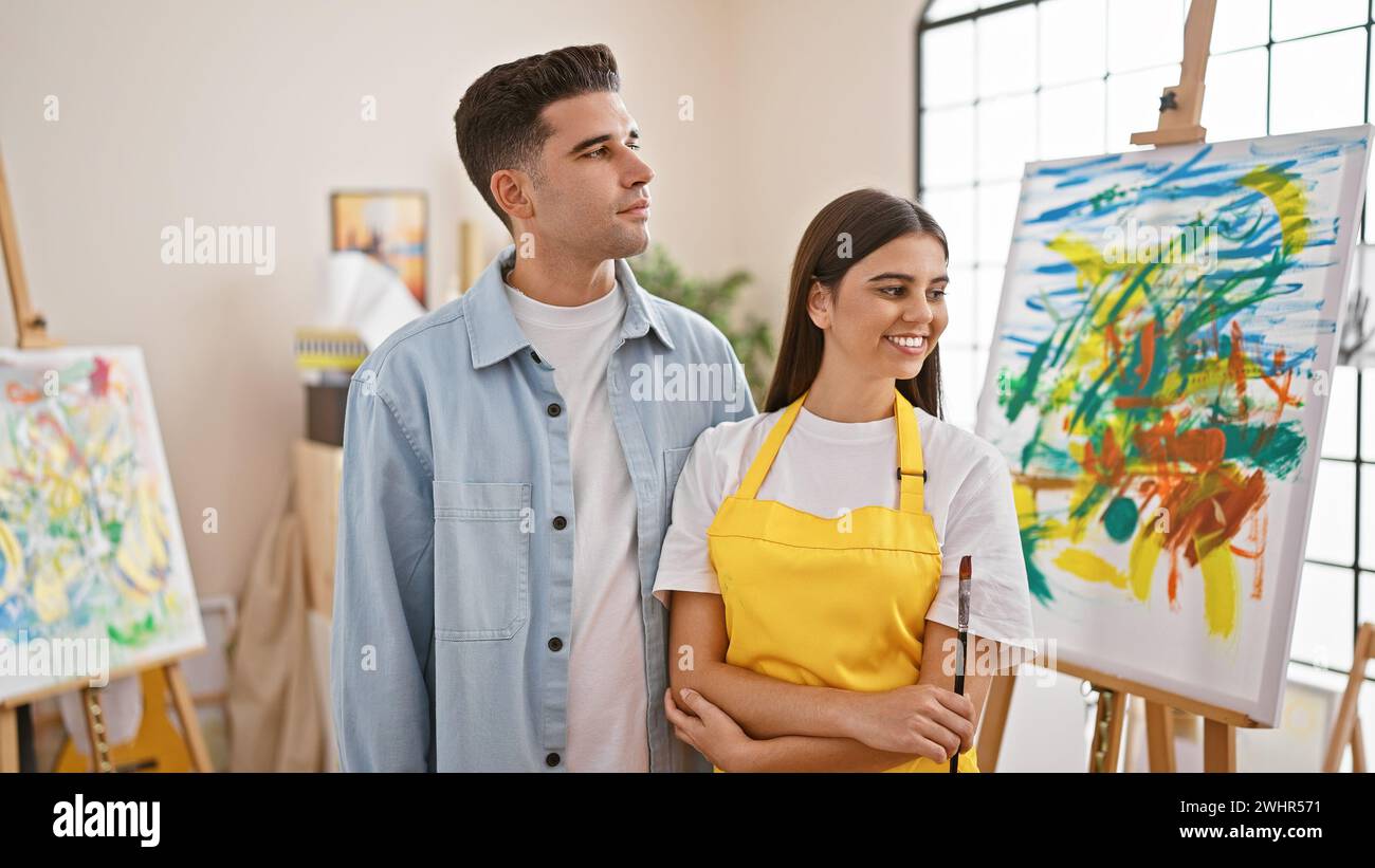 A man and woman, likely partners, stand confidently in a bright art ...