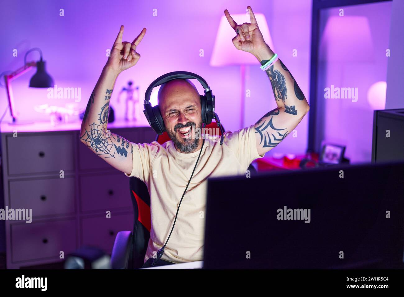 Young bald man streamer playing video game with winner expression at ...