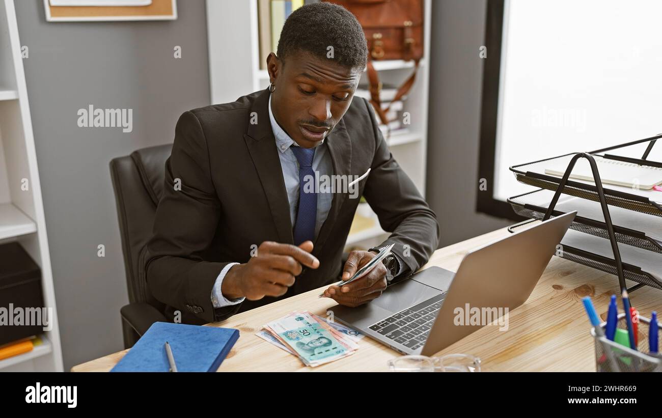 Focused african man counting chinese yuan in a modern office setting ...