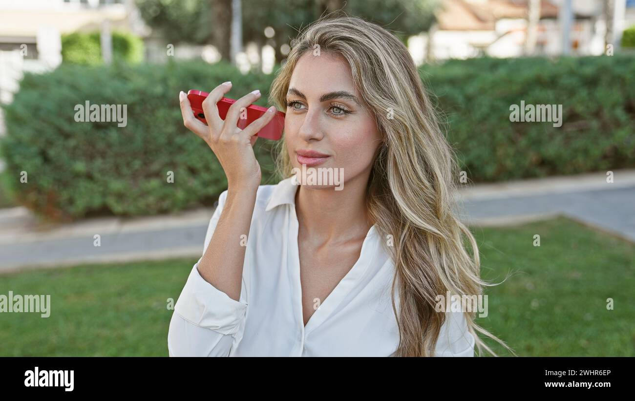 Cool, relaxed, young blonde woman seriously engrossed in listening to ...