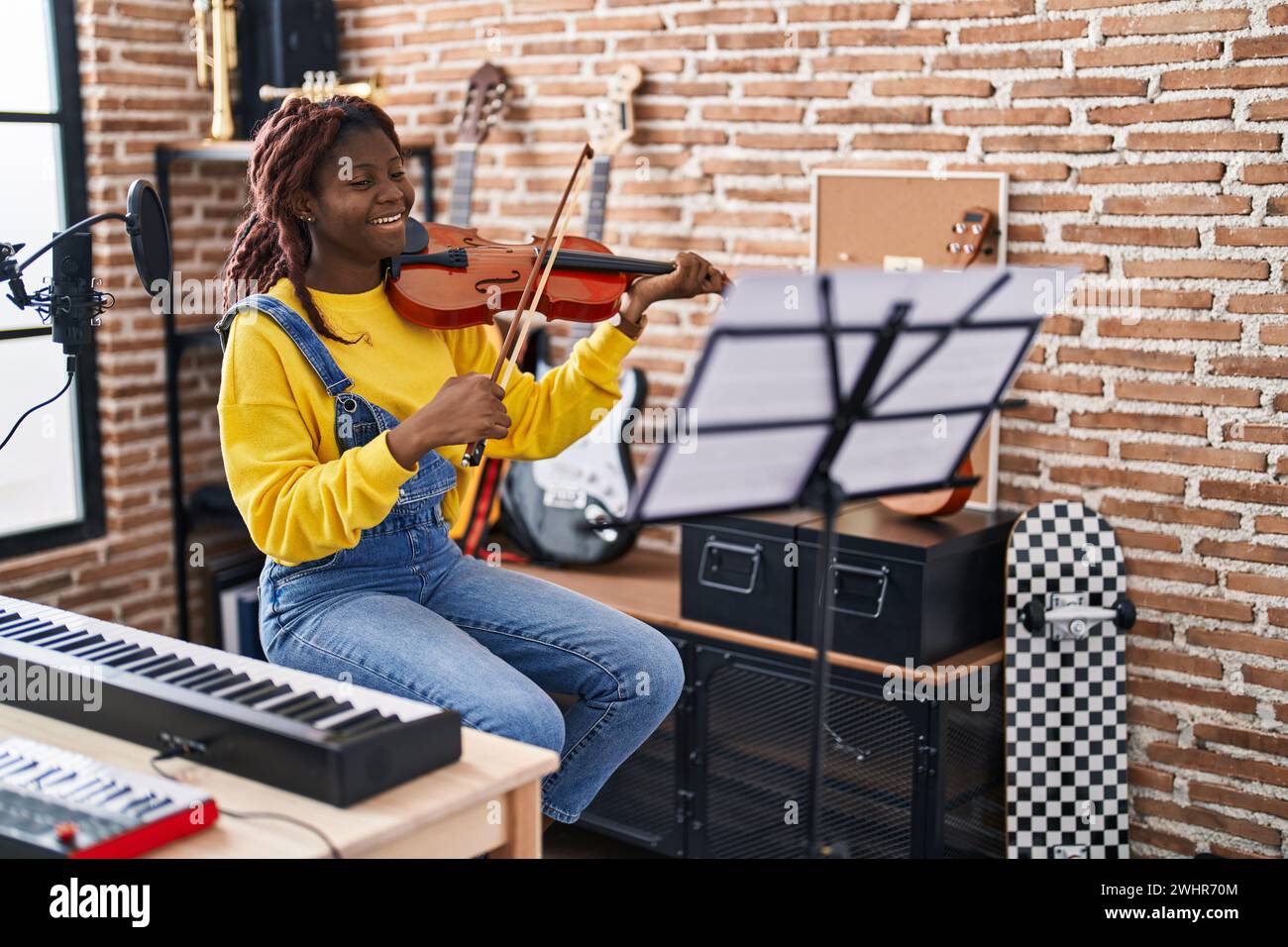 African american woman musician smiling confident playing violin at ...
