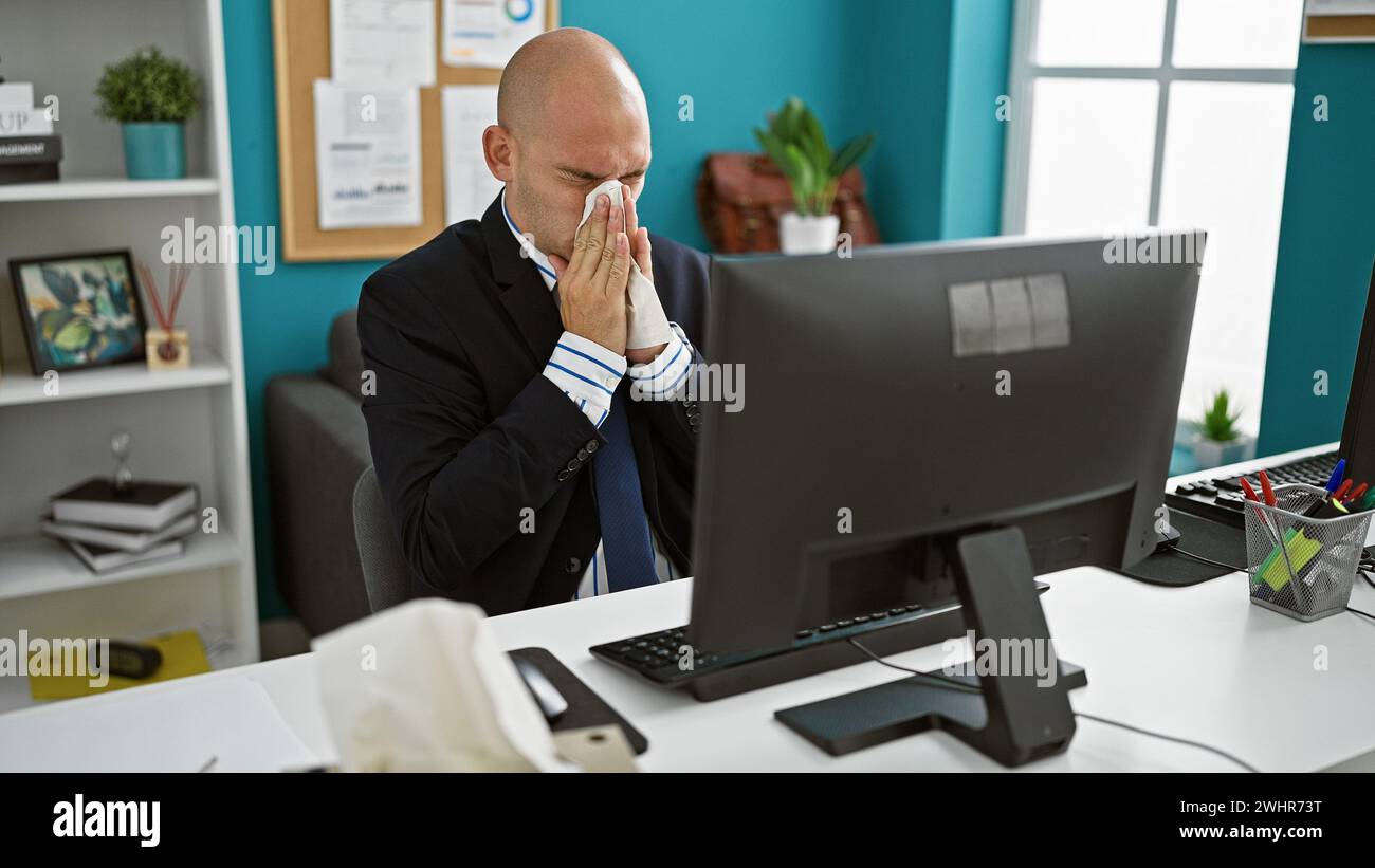 Young hispanic man business worker using computer sneezing at the ...