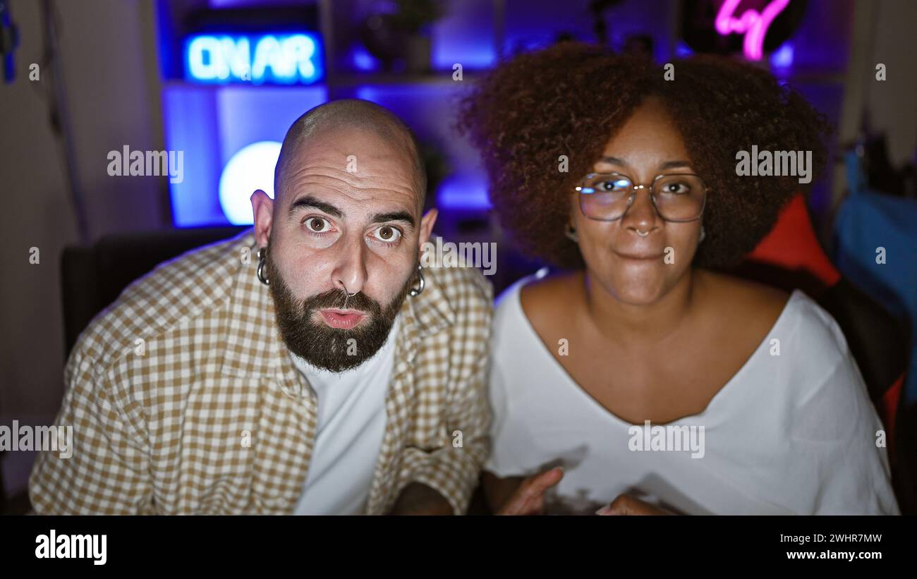 Two gamers, a man and a woman, immersed in a serious video game session ...