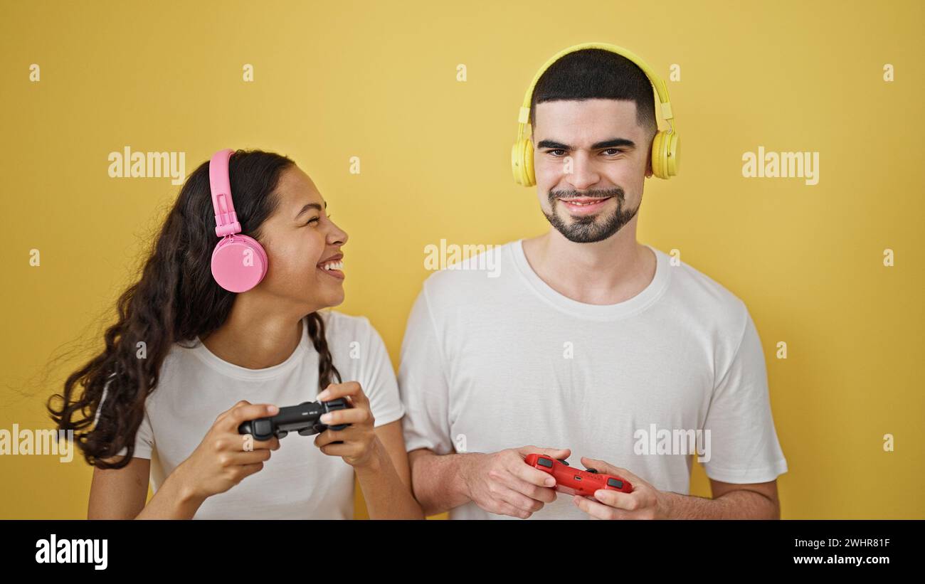 Smiling beautiful couple, confident, playing video game, laughing ...