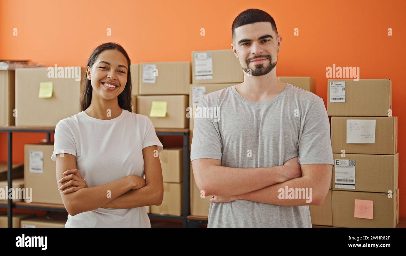 Two confident workers, man and woman, together smiling with arms ...