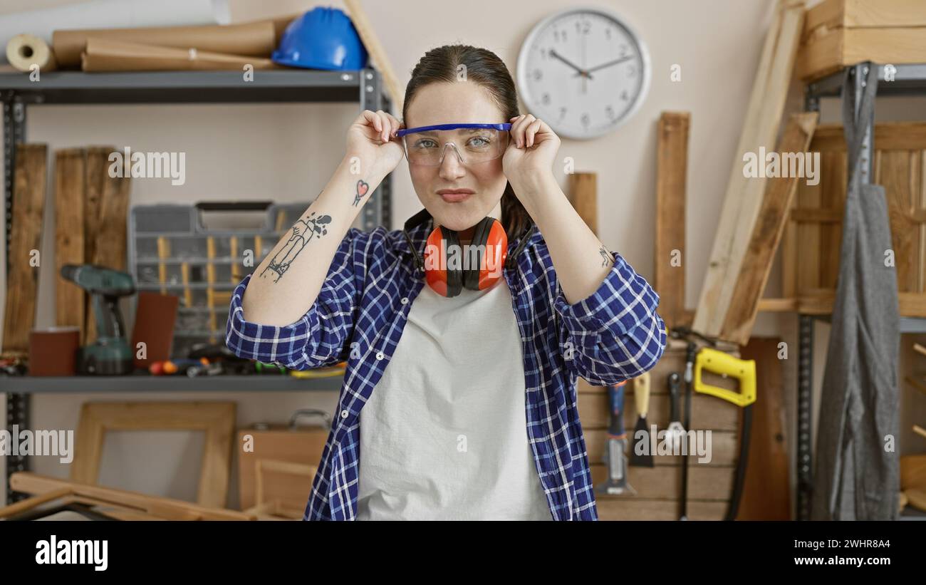 Caucasian woman with safety goggles in a carpentry workshop surrounded ...